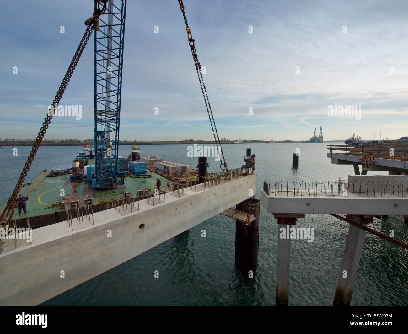 Large floating crane lifting a concrete block into place while building ...