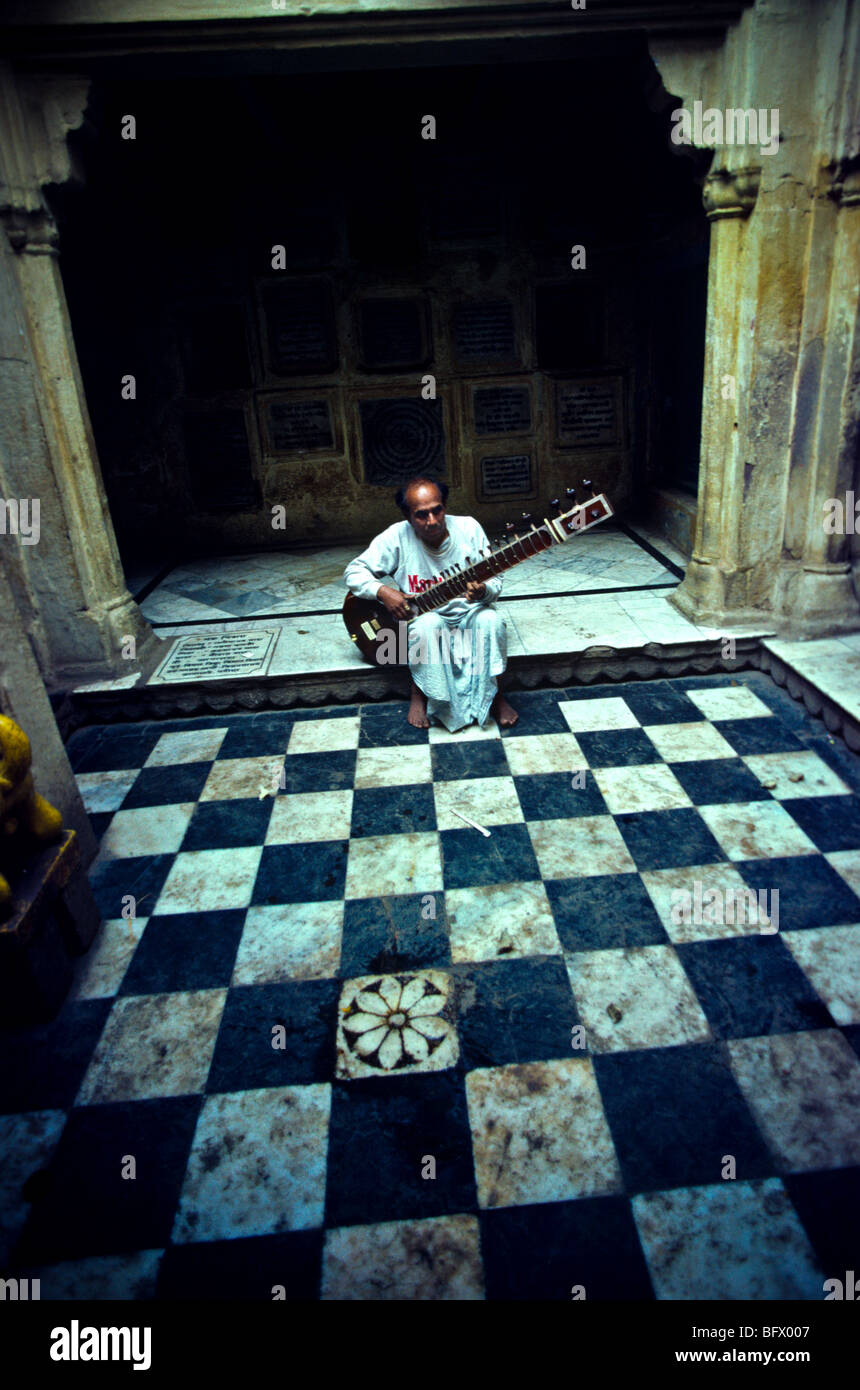 An Indian musician practices the sitar in a temple courtyard in ...