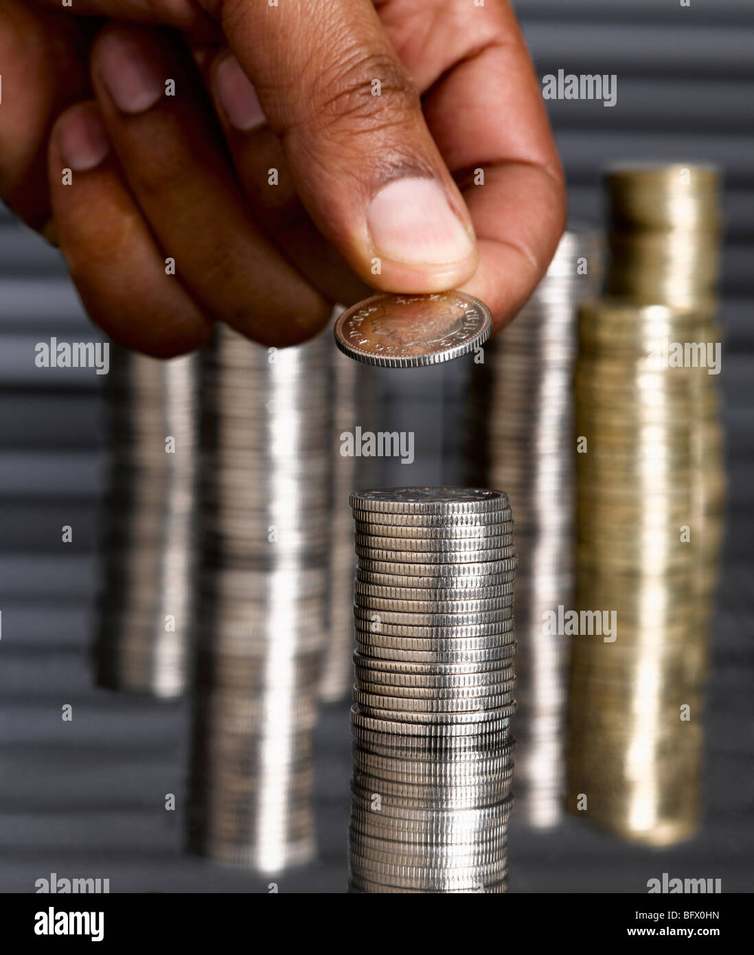 Man stacking sterling coins Stock Photo - Alamy