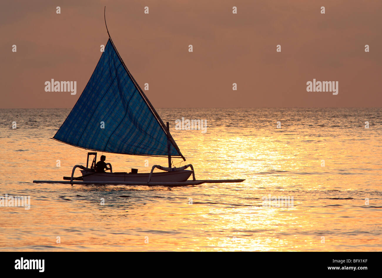 Jukung, or traditional Balinese fishing boat with fisherman and sail ...