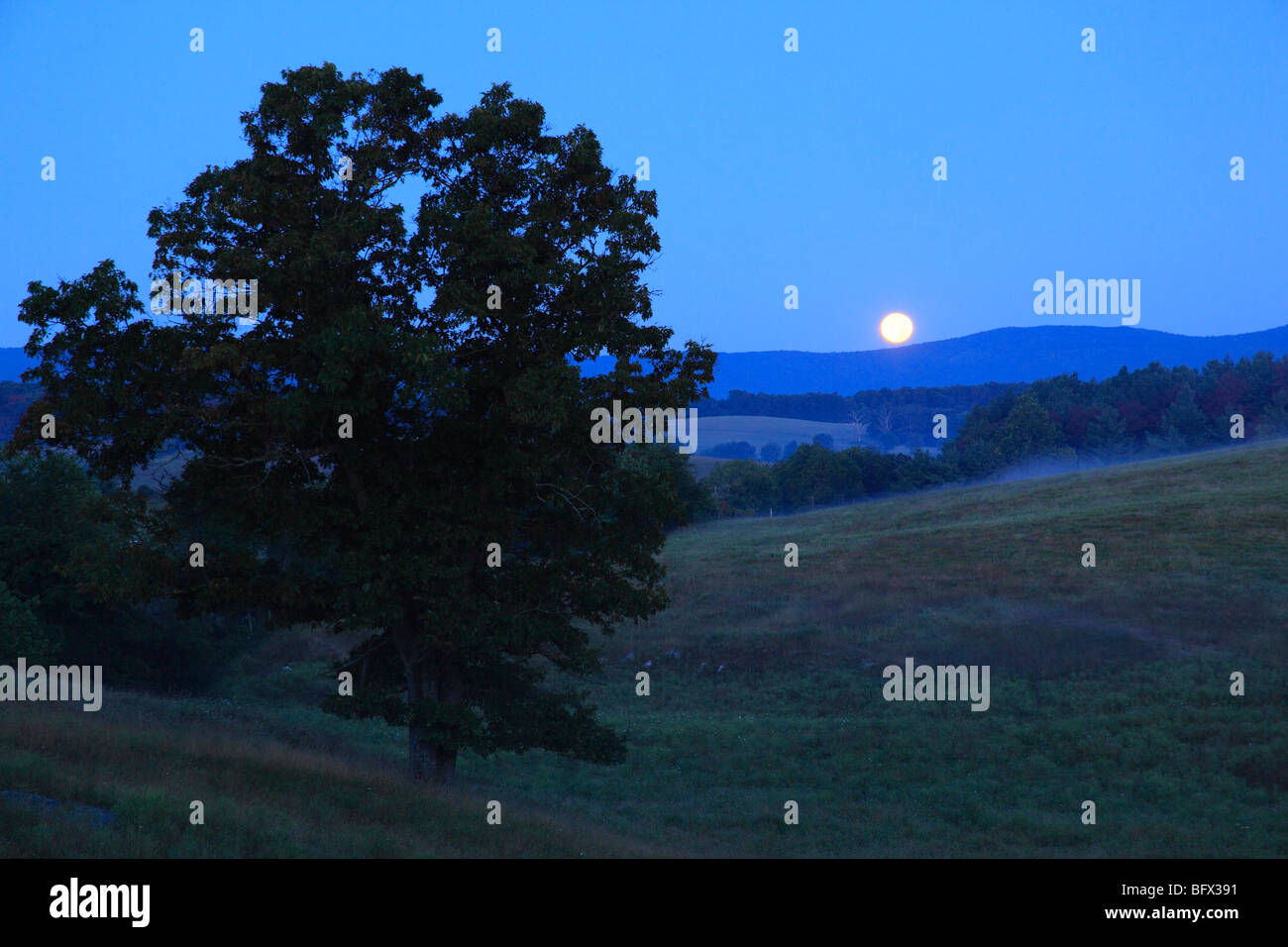 Full moon sets behind Blue Ridge Mountains on farm in Swoope ...