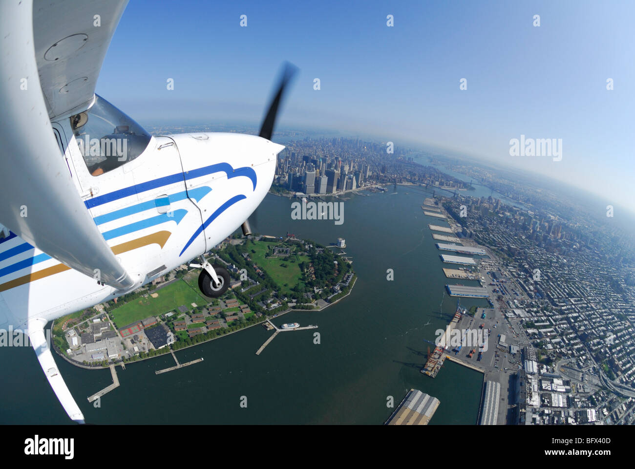 A light plane Cessna 172 flying over Governors island, Manhattan, East ...