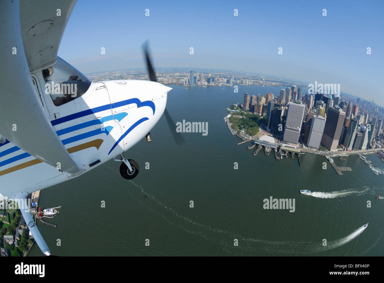 A light plane Cessna 172 flying over Lower Manhattan and Hudson river ...