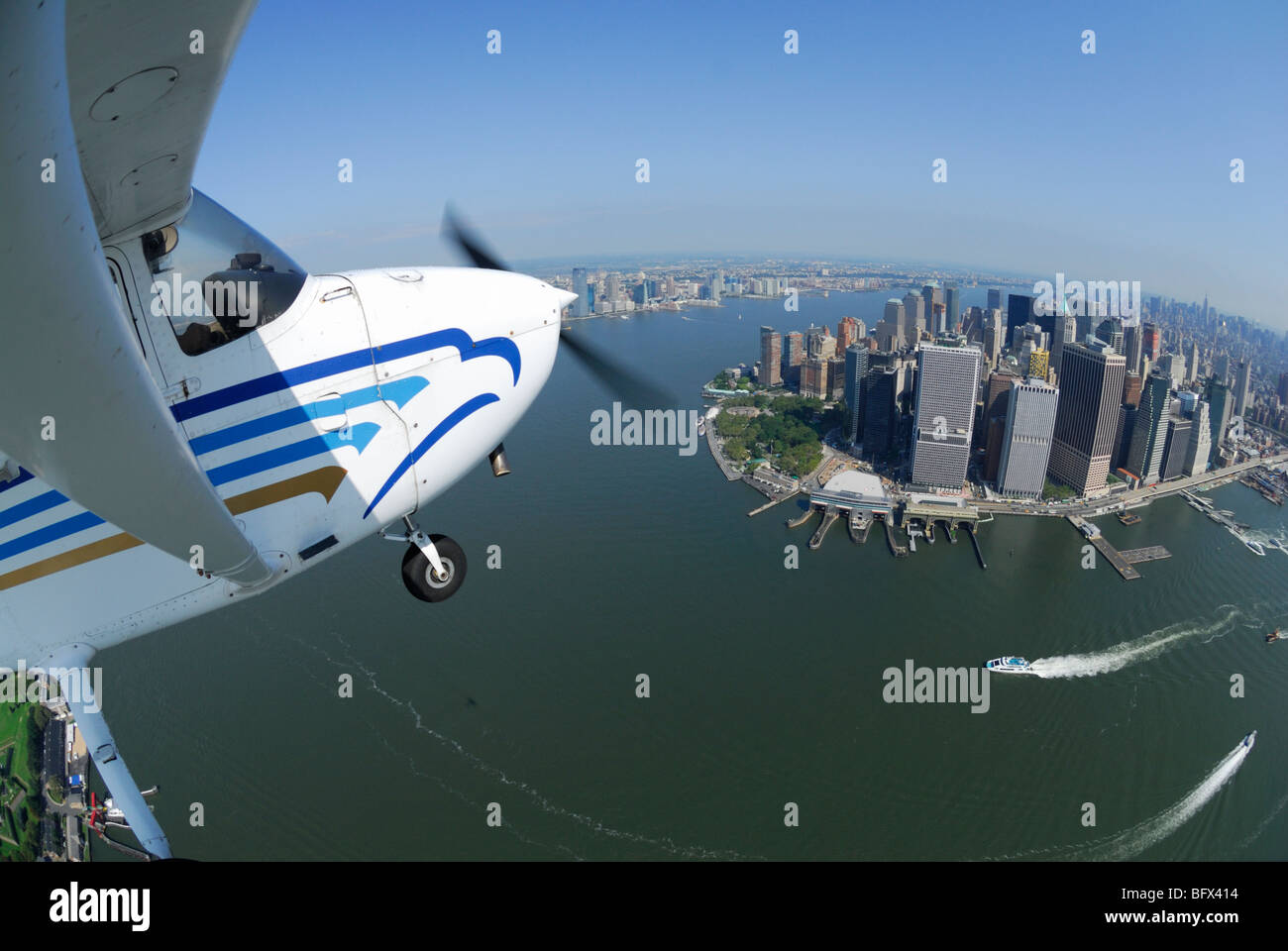 A light plane Cessna 172 flying over Lower Manhattan and Hudson river ...