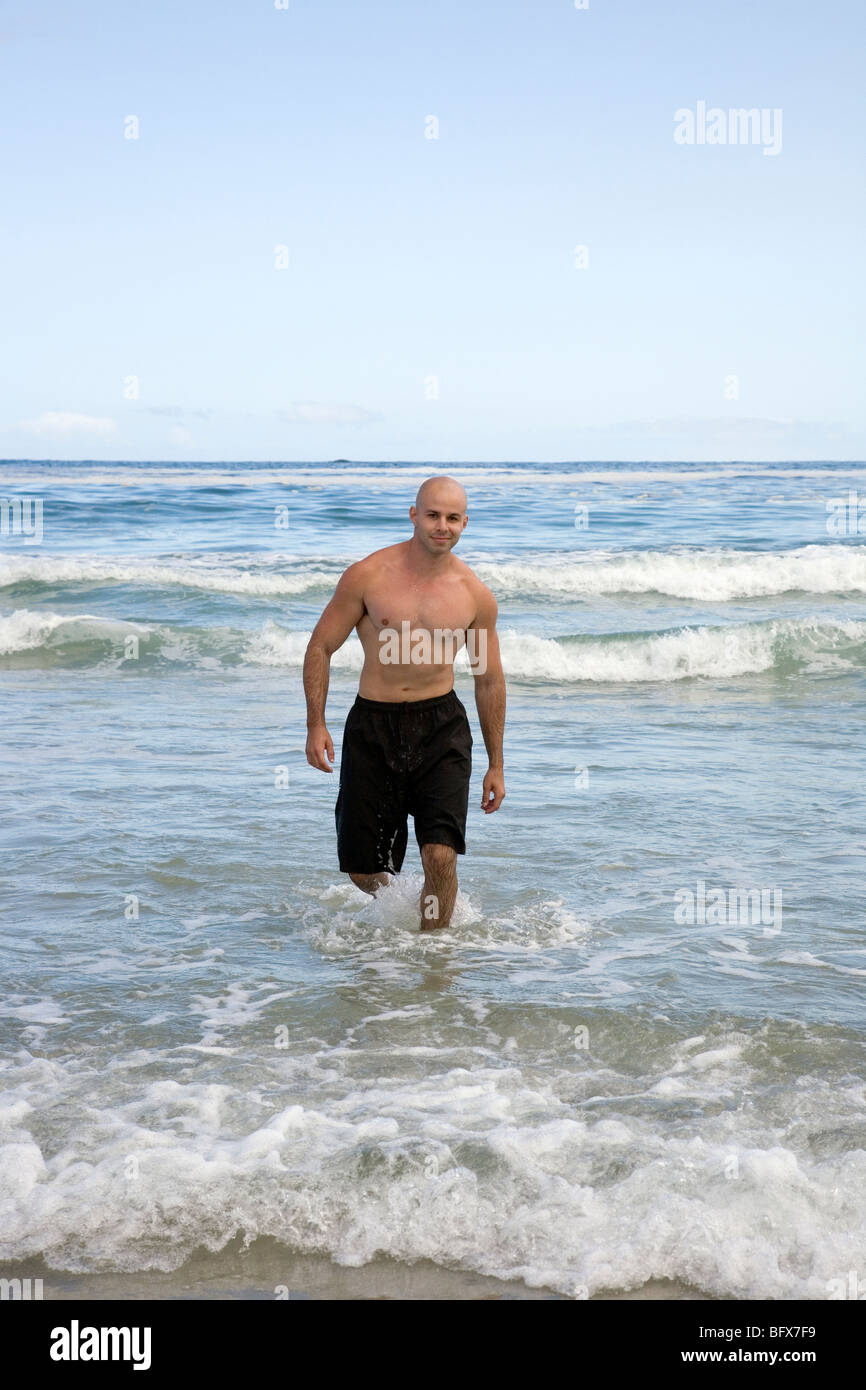Muscle Man running out of ocean Stock Photo - Alamy