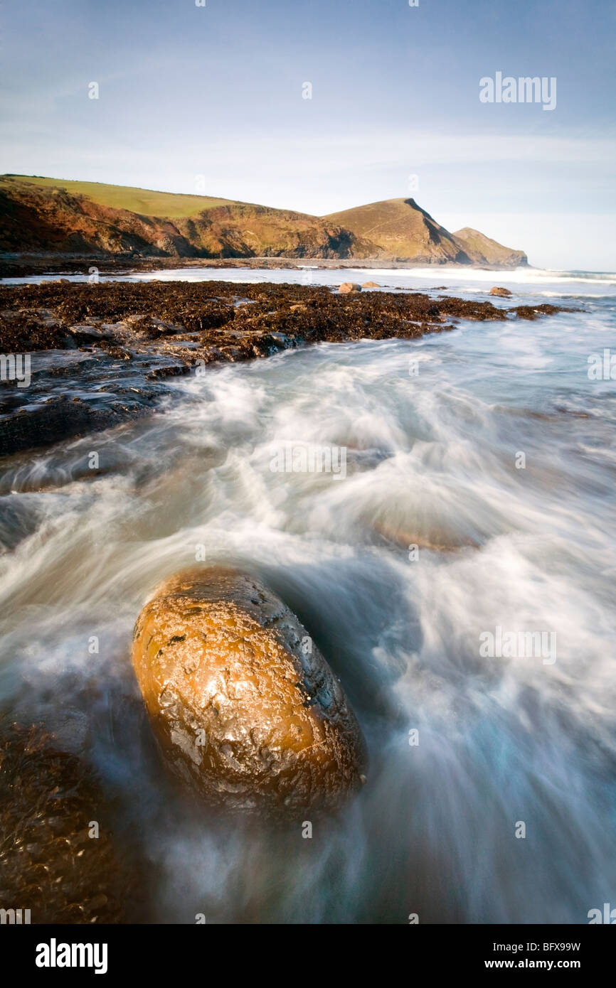Sea water flowing around a boulder in Cornwall Stock Photo - Alamy