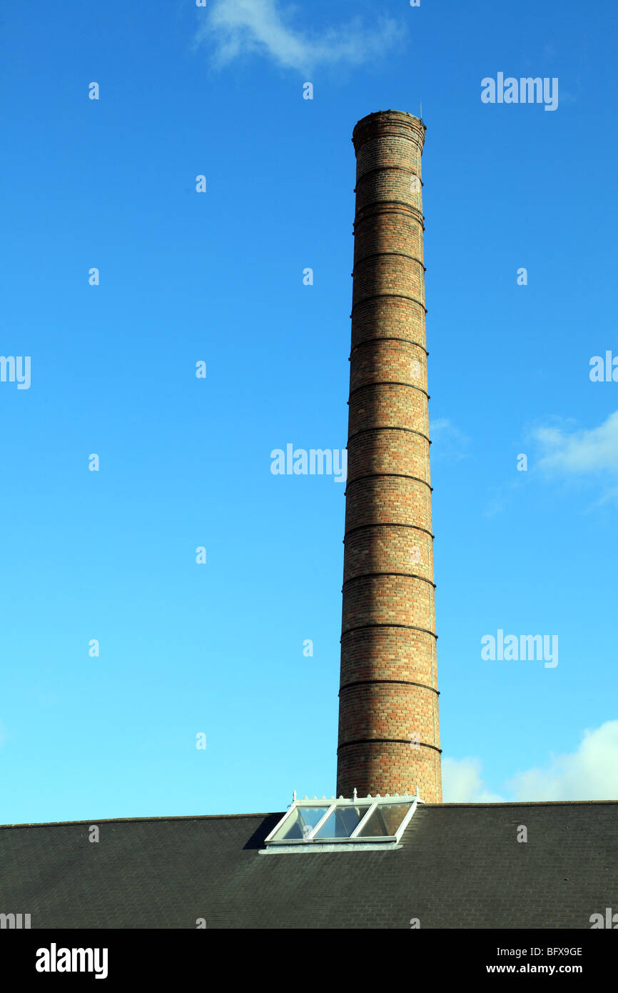 A tall industrial factory chimney against a blue sky Stock Photo - Alamy