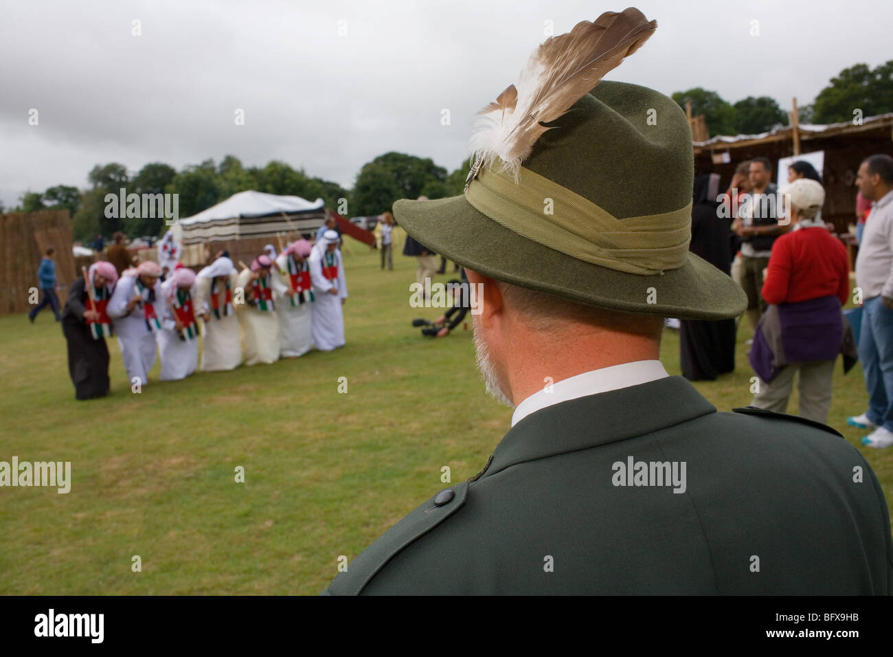 A man wearing a traditional Austrian hat watches a dance by Emirate men ...