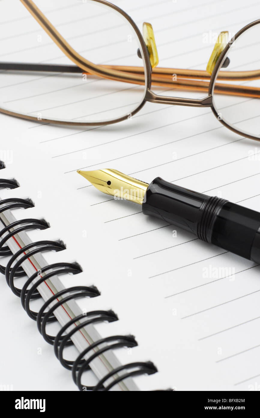 Spectacles and fountain pen on writing pad Stock Photo - Alamy