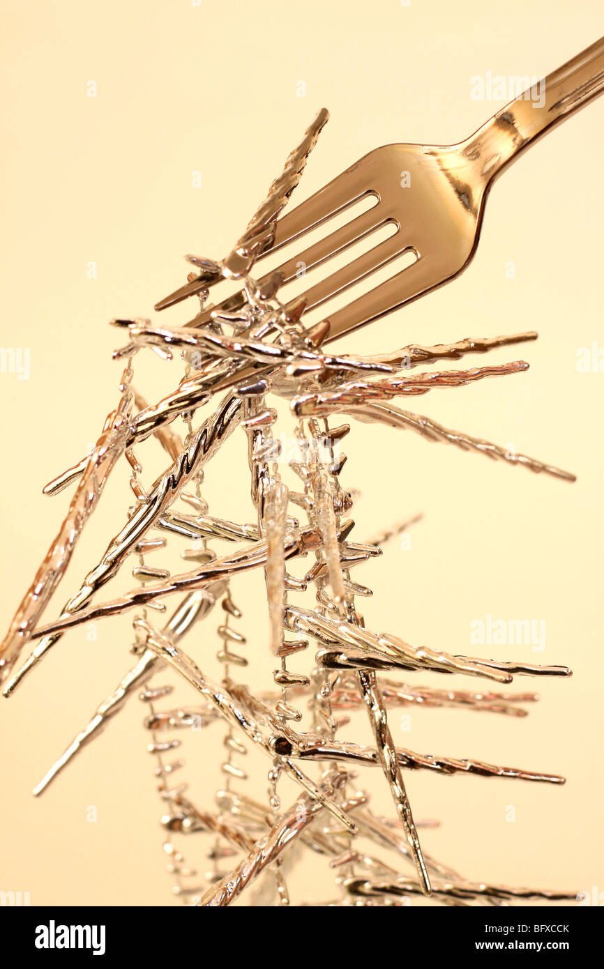 Fork picking up gold and silver Christmas icicles Stock Photo - Alamy