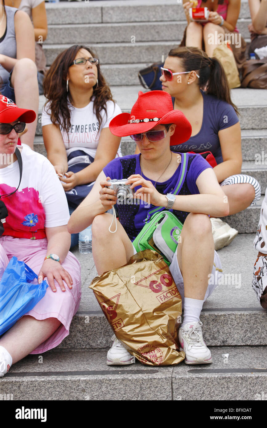 Woman wearing a red Stetson looks at the images she's taken on her ...