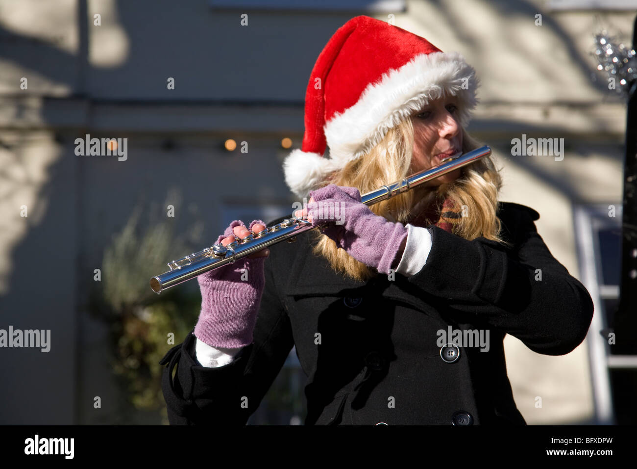 A girl plays festive music on her flute at a Christmas Fair Stock Photo ...