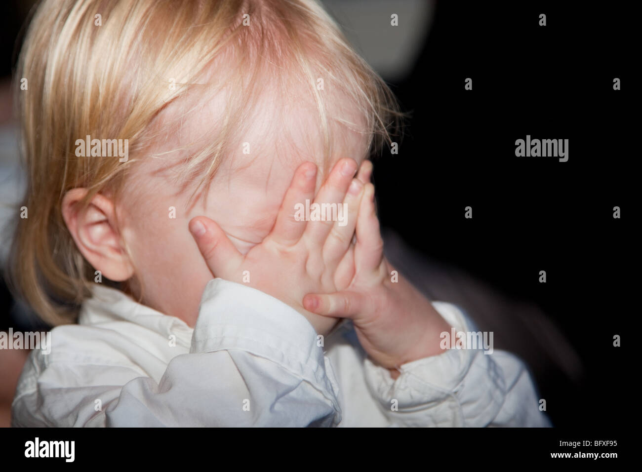 Toddler covering face with hands and crying Stock Photo - Alamy