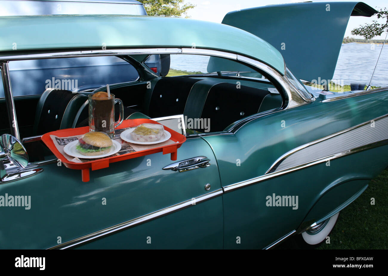 Old fashioned or vintage car with a food tray of a hamburger and soft ...
