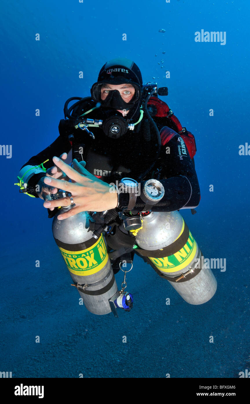 Technical scuba diver diving underwater with multiple cylinders Ras Abu ...