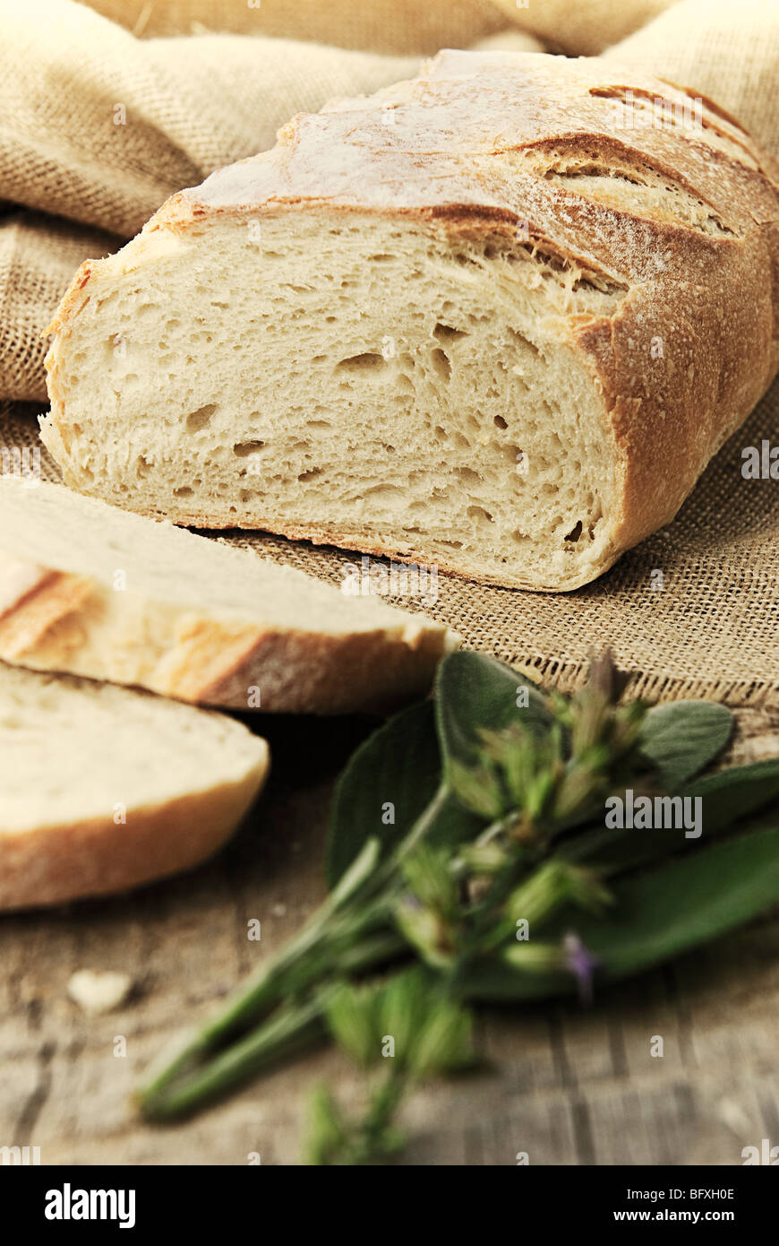 Freshly baked loaf of bread, just sliced with fresh herbs Stock Photo ...