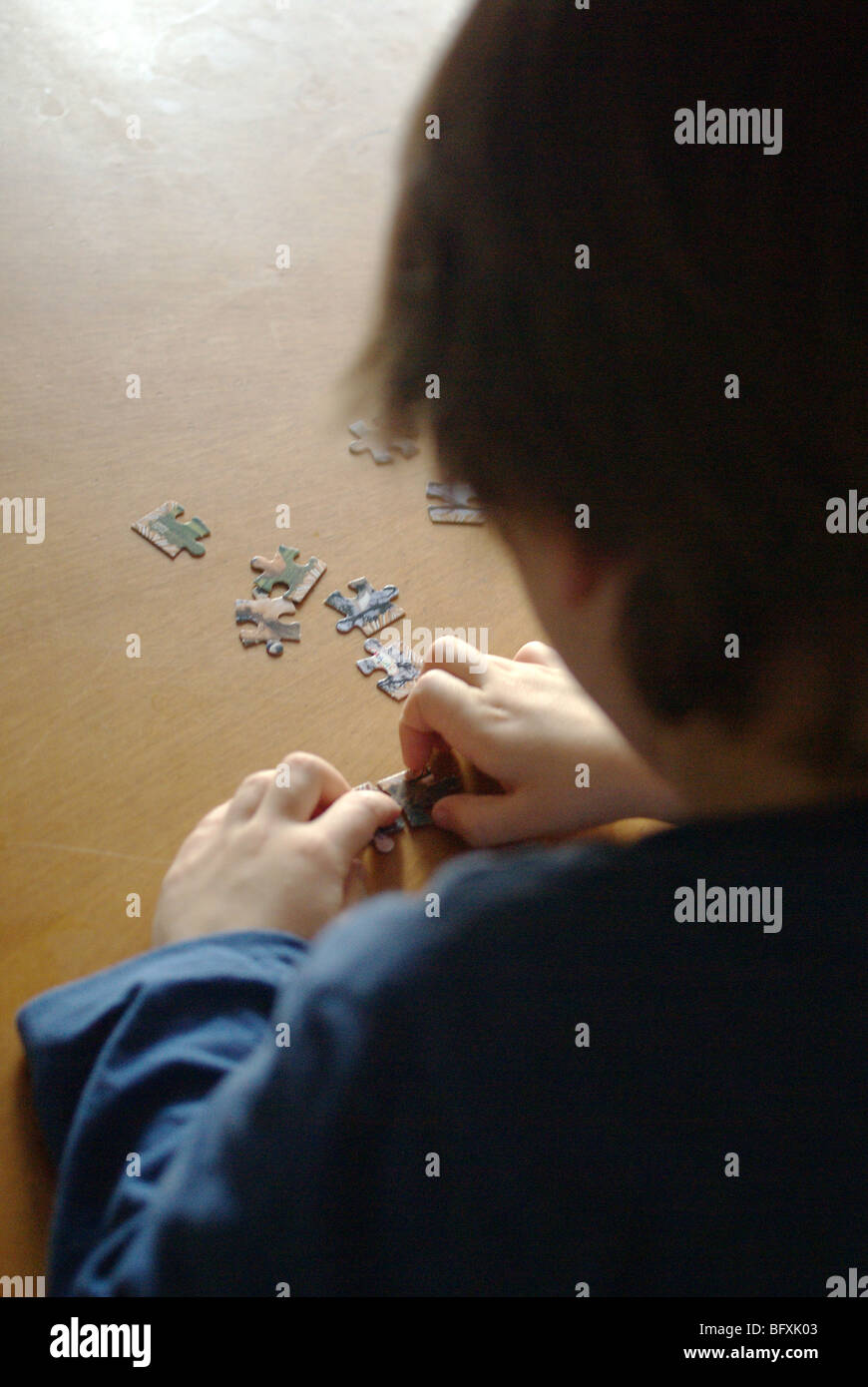 child makes a puzzle Stock Photo - Alamy
