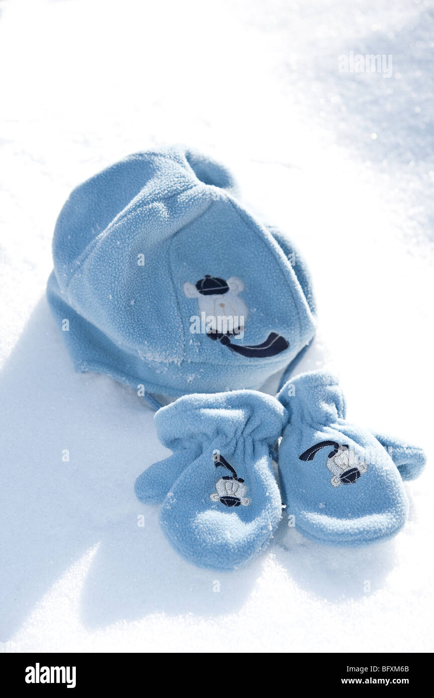 Baby mittens and hat in snow Stock Photo - Alamy