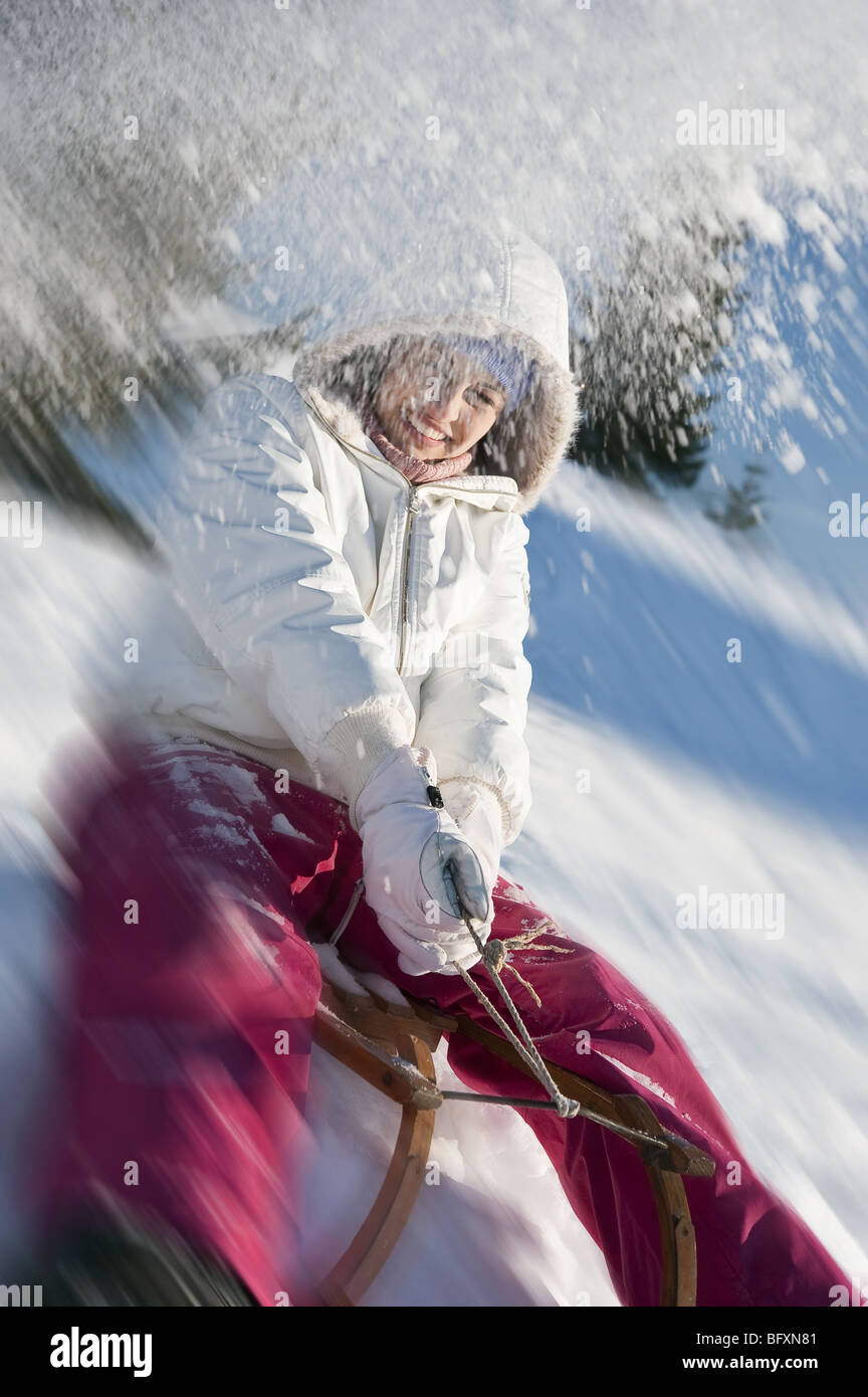 Young woman sledding Stock Photo - Alamy