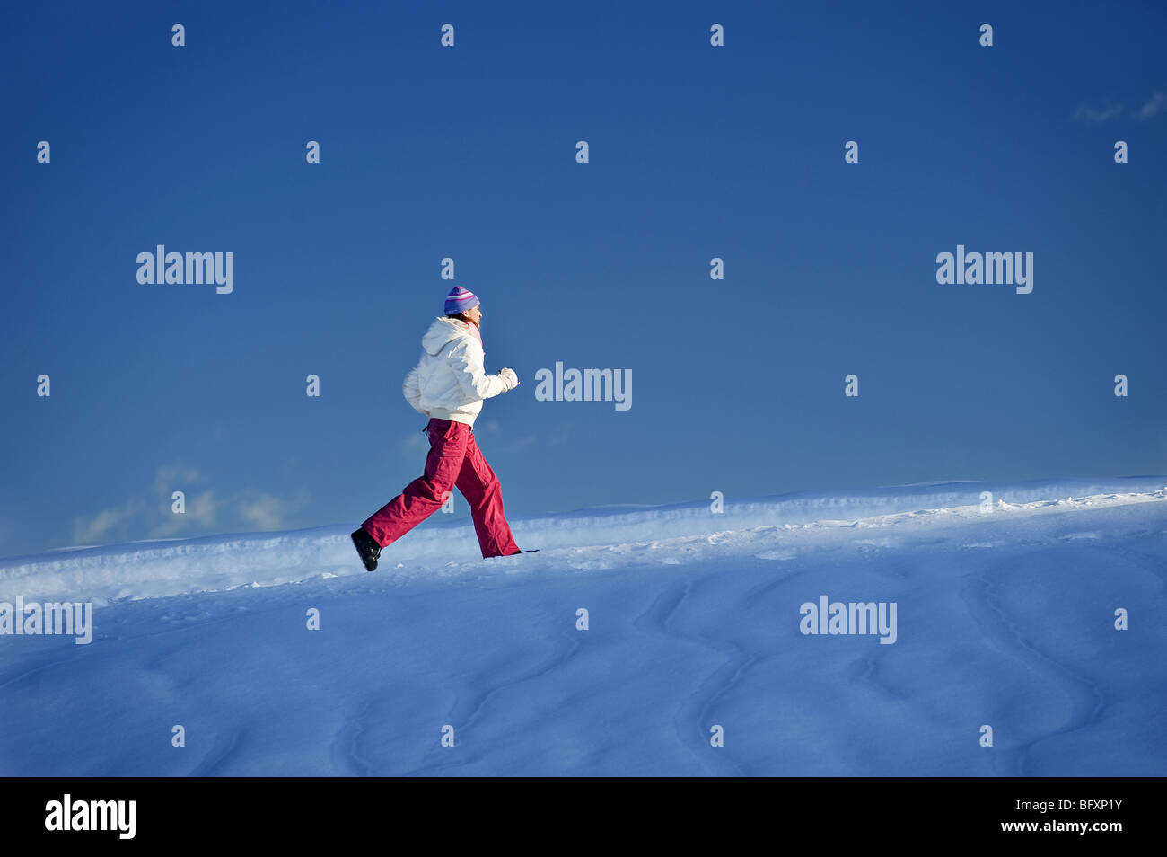 Young woman running in snow Stock Photo - Alamy