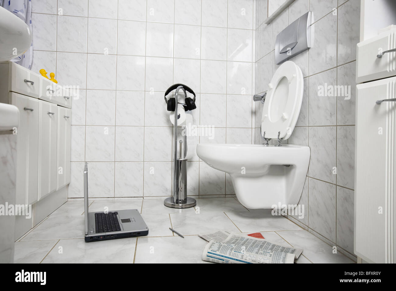 Newspaper, laptop and pen on floor by toilet Stock Photo - Alamy