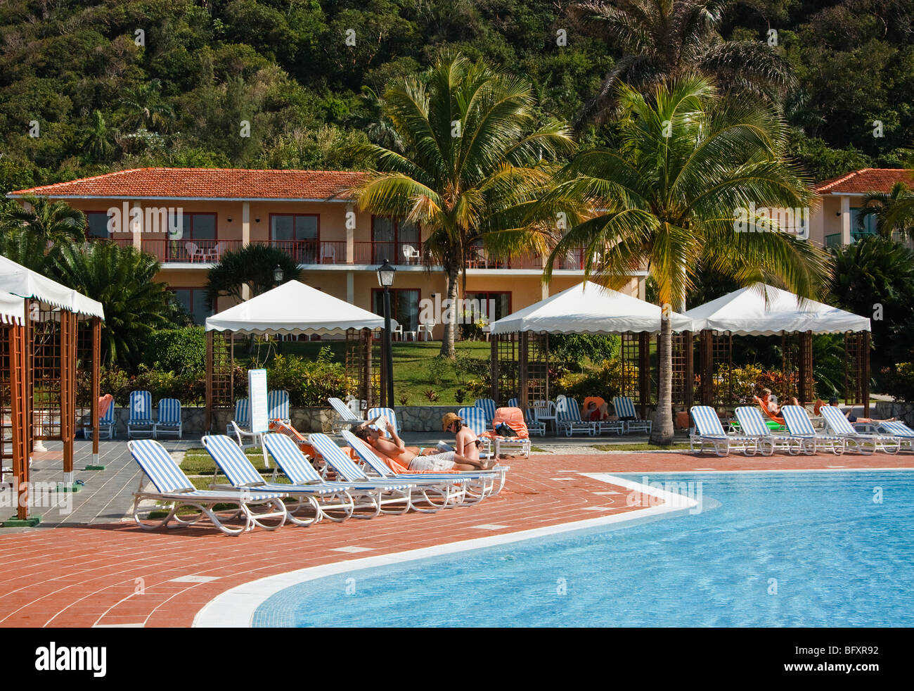 People resting by the pool at a Caribbean resort, Cuba Stock Photo - Alamy