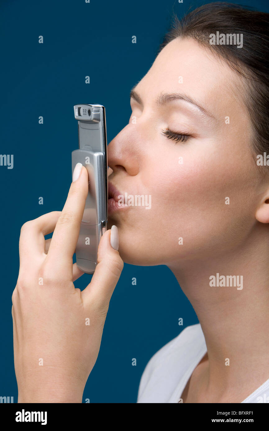 Close up of woman kissing cell phone Stock Photo - Alamy