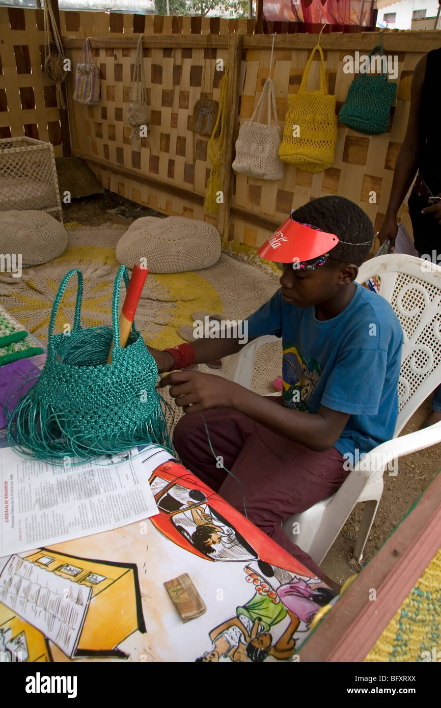 Young boy weaving a bag on craft stand at Carnival in Bonapriso ...