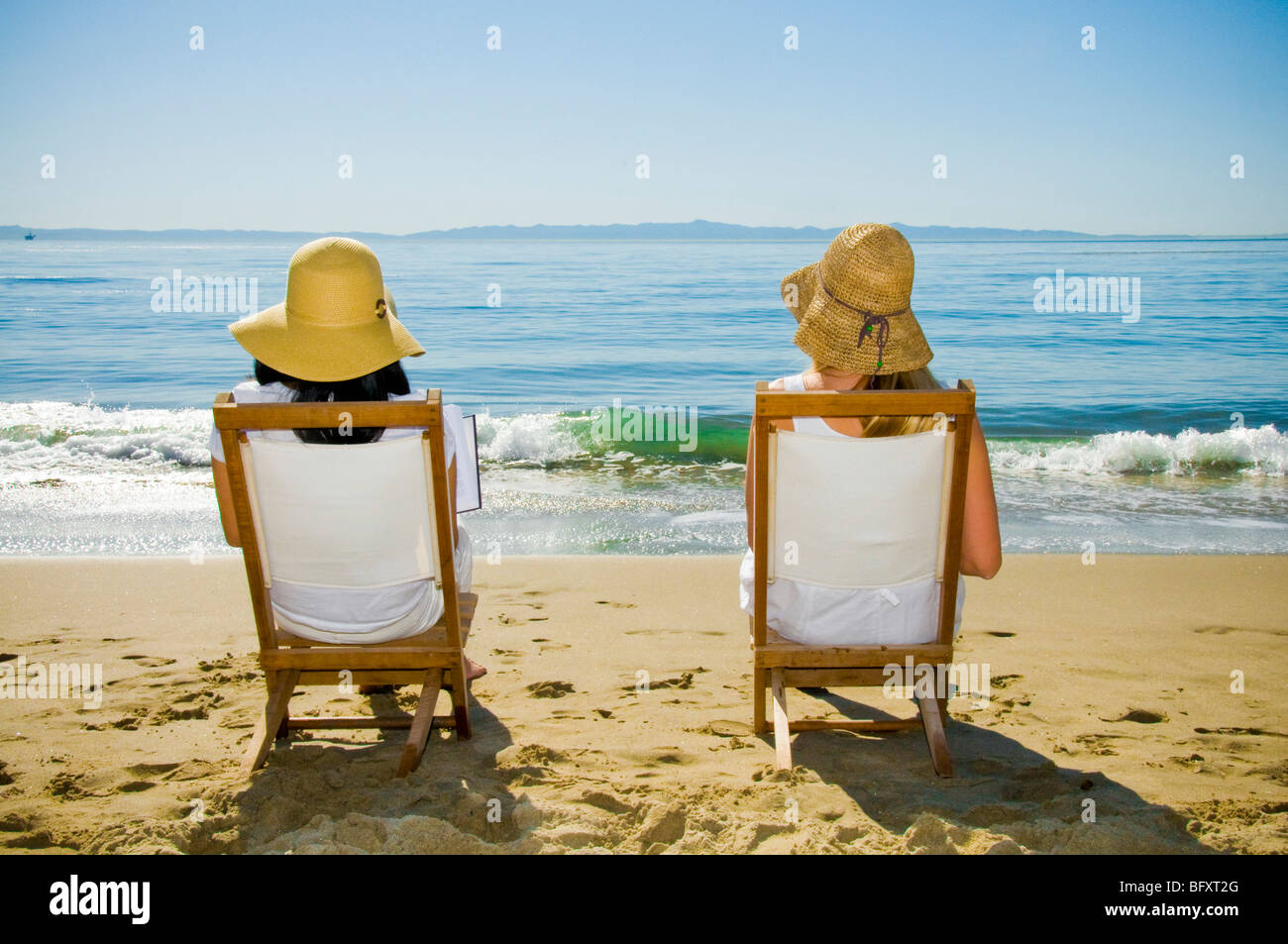 Woman reading books in chairs on beach Stock Photo - Alamy