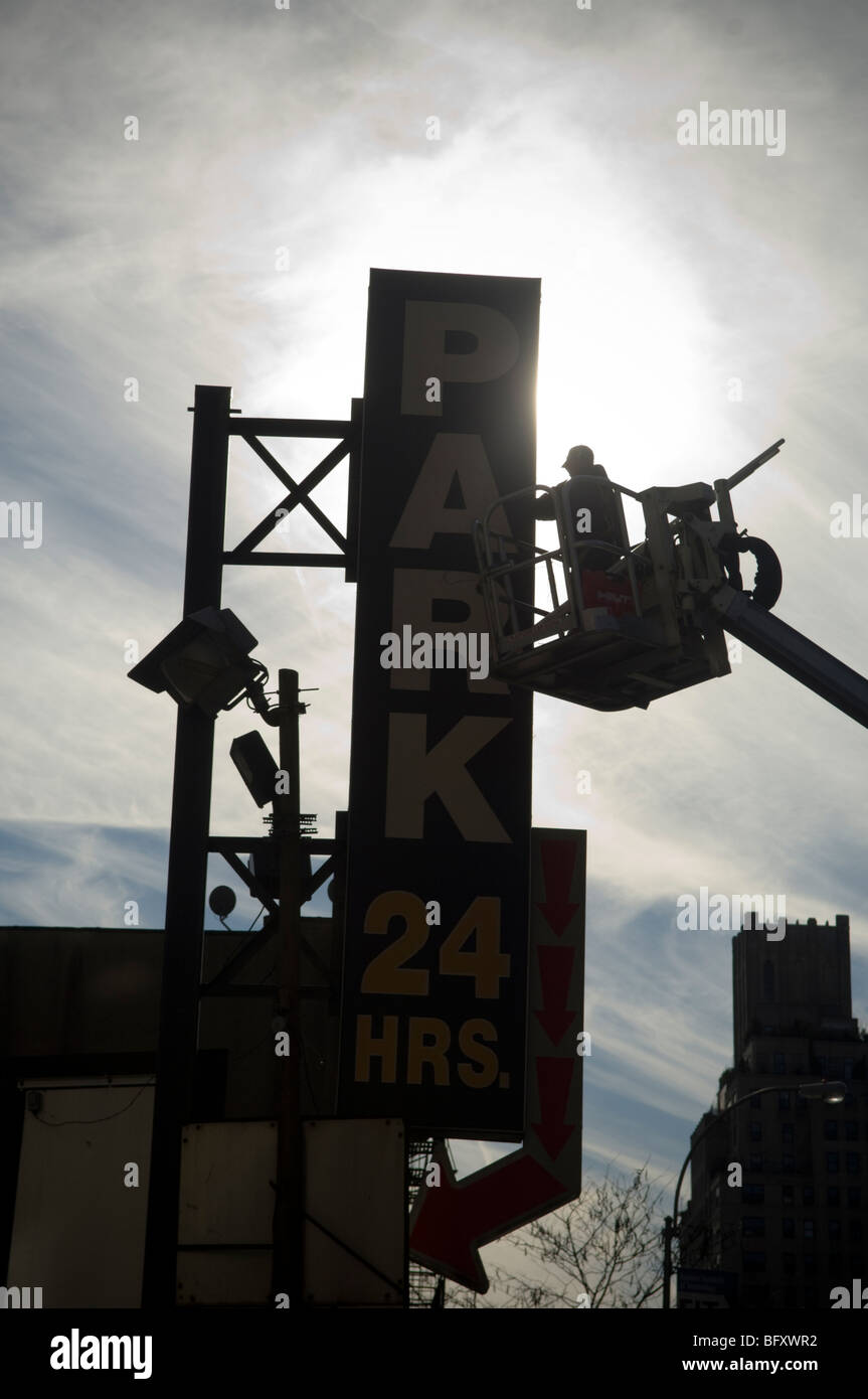 A workman works on a park 24 hours sign in the Chelsea neighborhood of ...