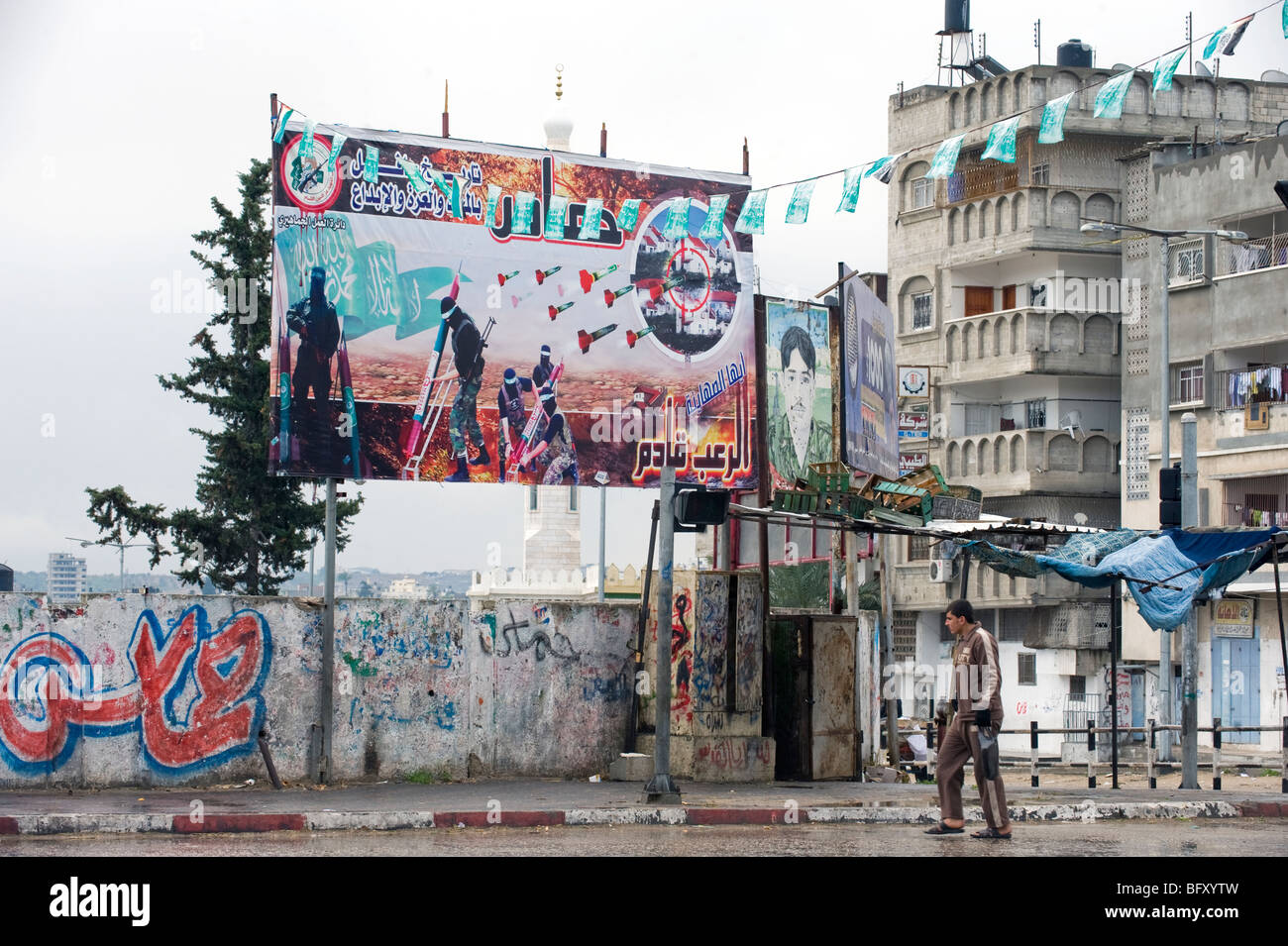Palestinian man walks past a Hamas poster in the northern Gaza Strip ...
