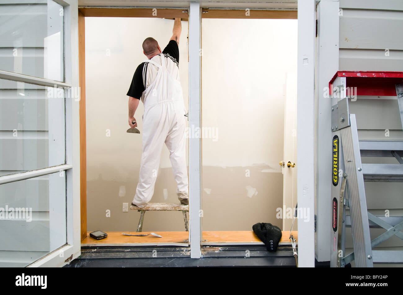 Man and apprentice plastering room Stock Photo - Alamy