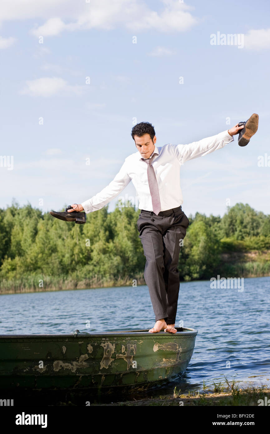 businessman balancing on rowboat Stock Photo - Alamy