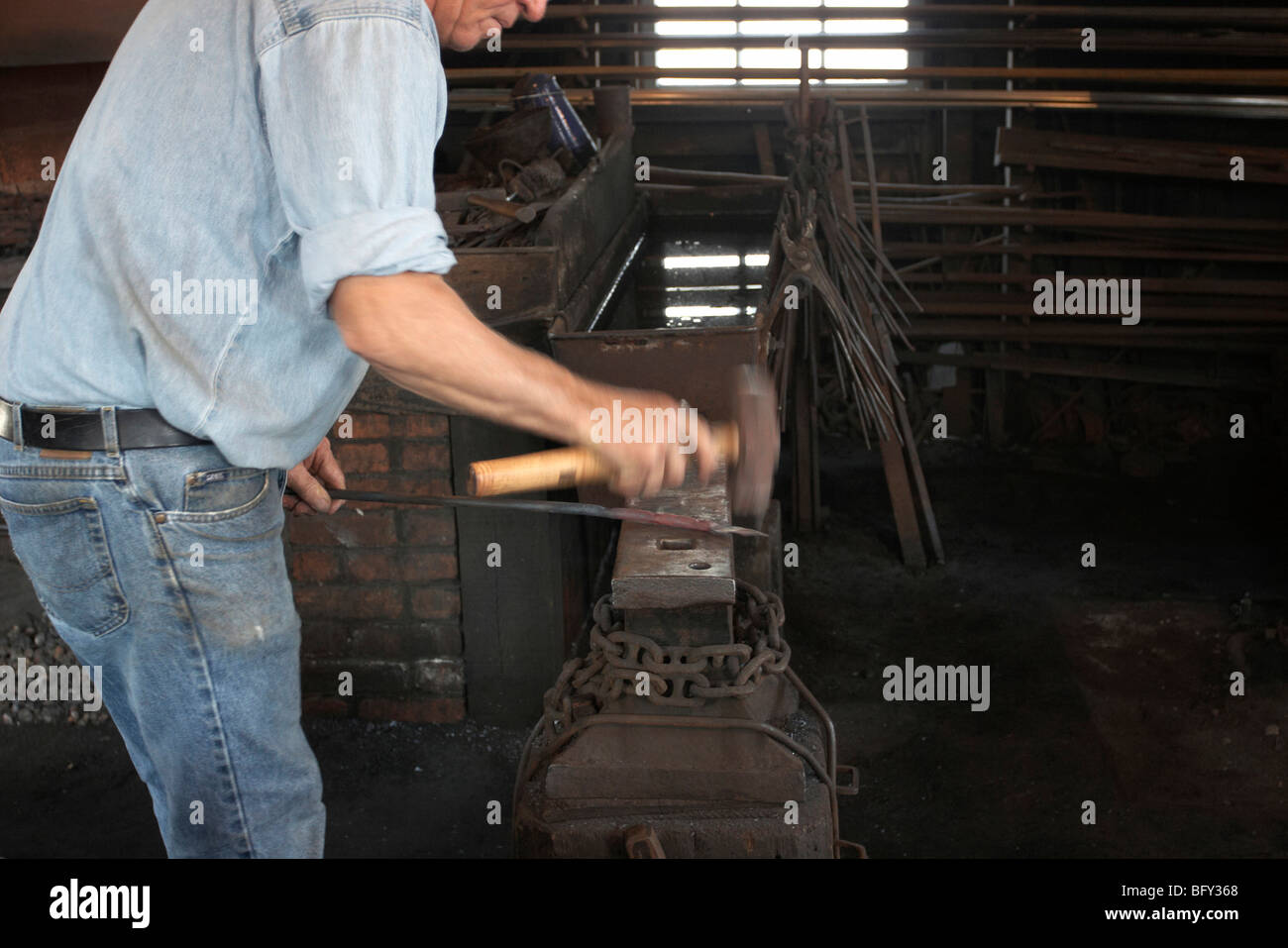 A blacksmith working with a hammer and anvil Stock Photo - Alamy