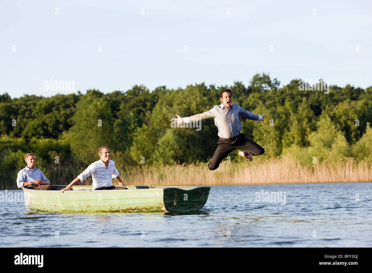 Young man jumping from boat hi-res stock photography and images - Alamy