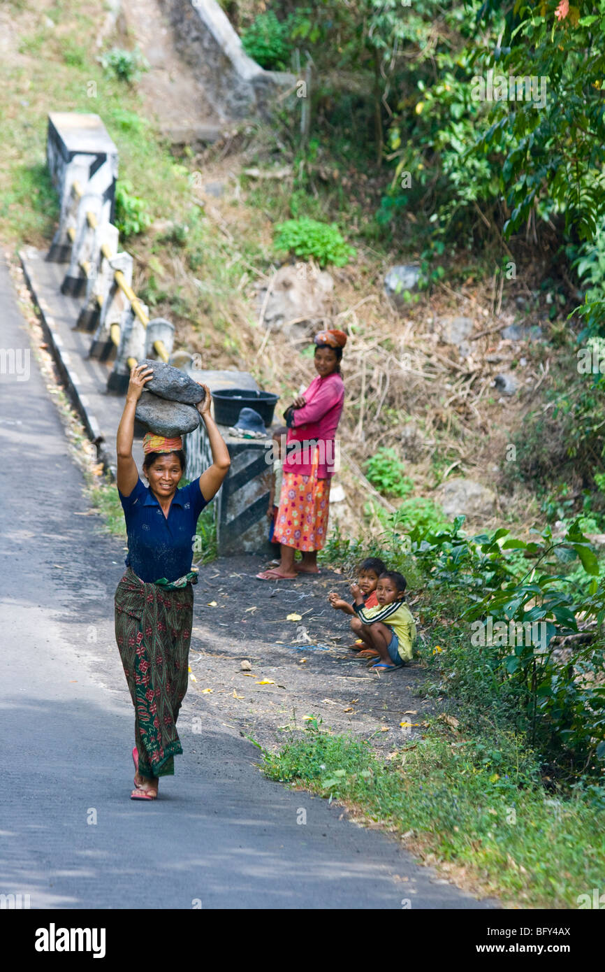Woman carrying heavy stones on Lombok Island in Indonesia Stock Photo ...