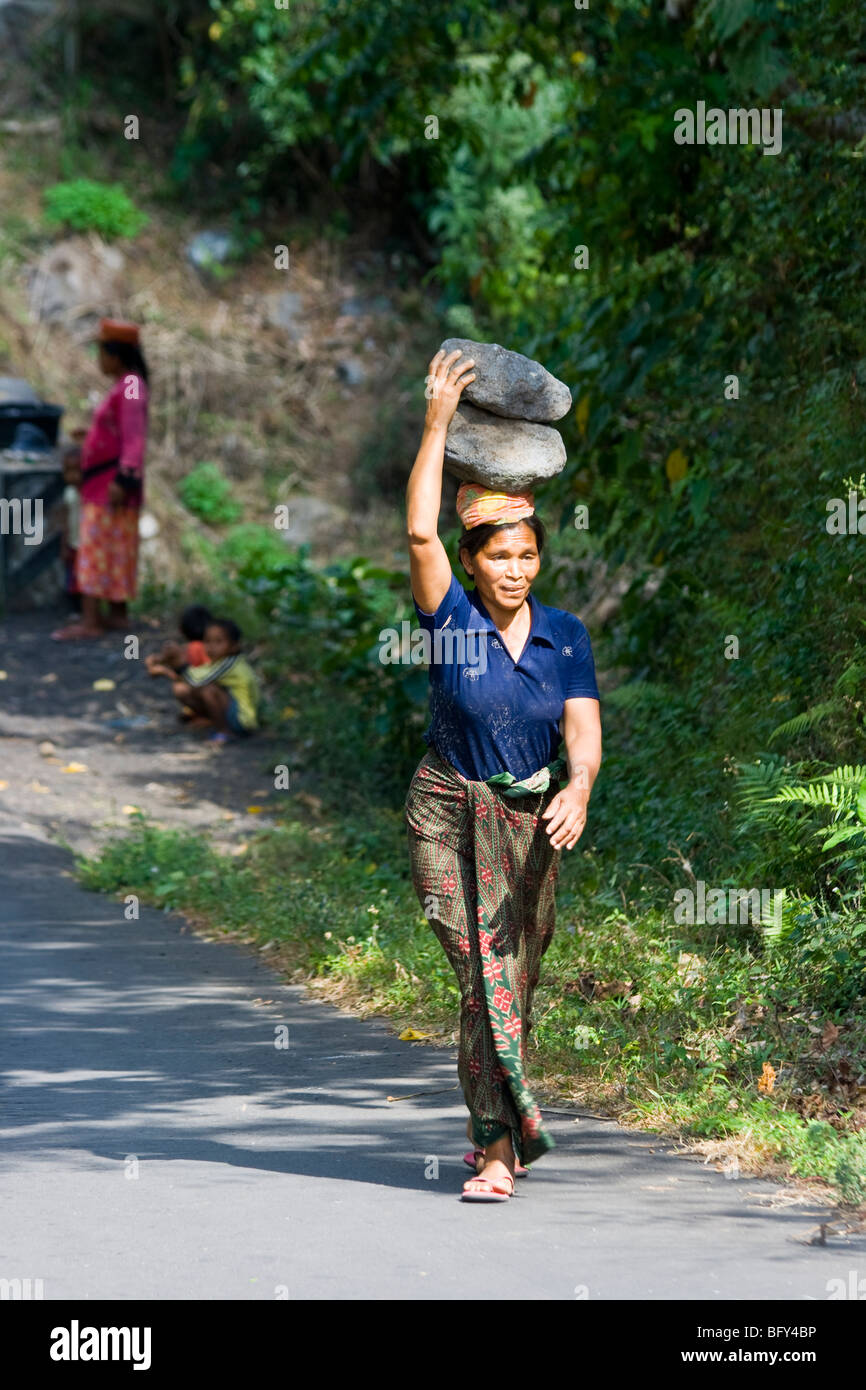 Woman carrying heavy stones on Lombok Island in Indonesia Stock Photo ...