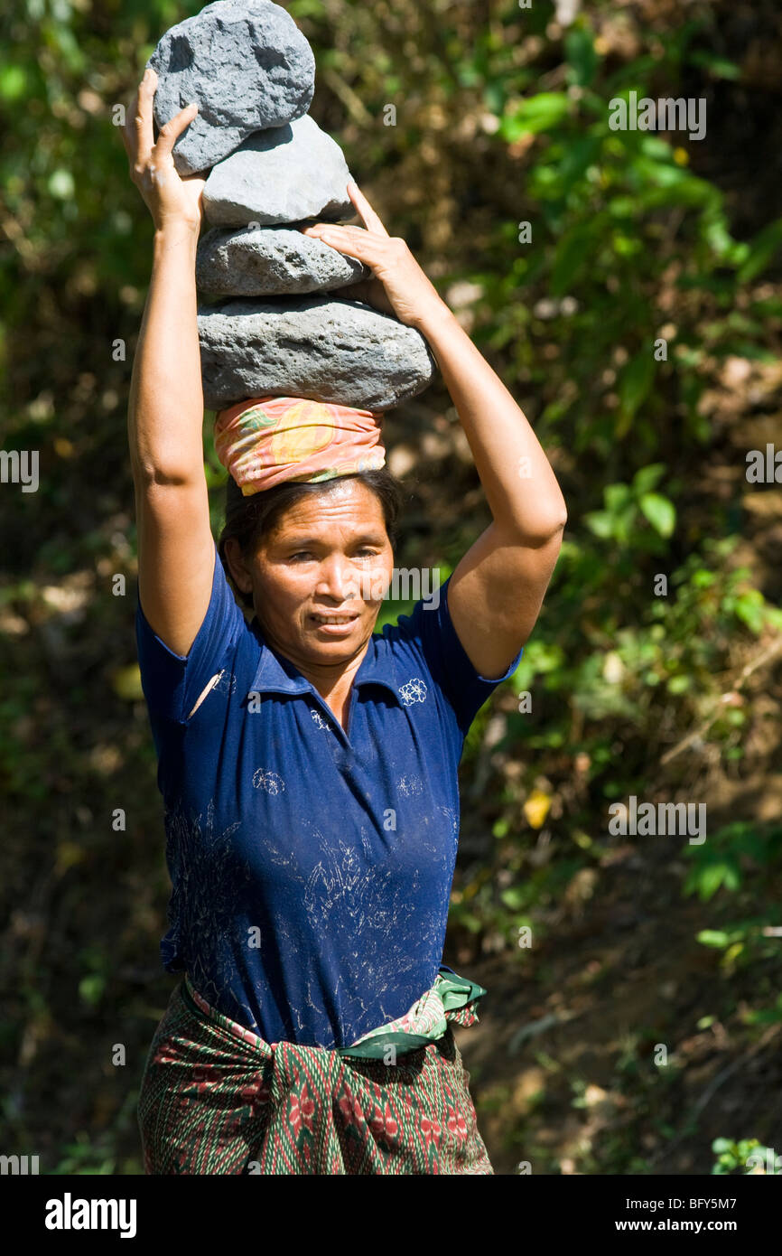 Woman carrying heavy stones on Lombok Island in Indonesia Stock Photo ...