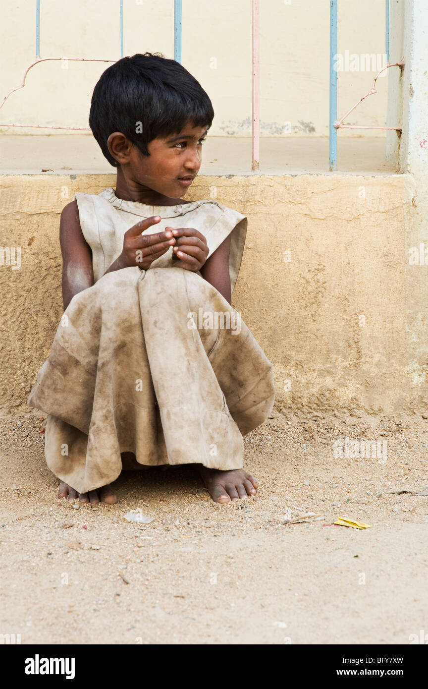 Young poor Indian girl leaning against a wall, alone on the street, in ...