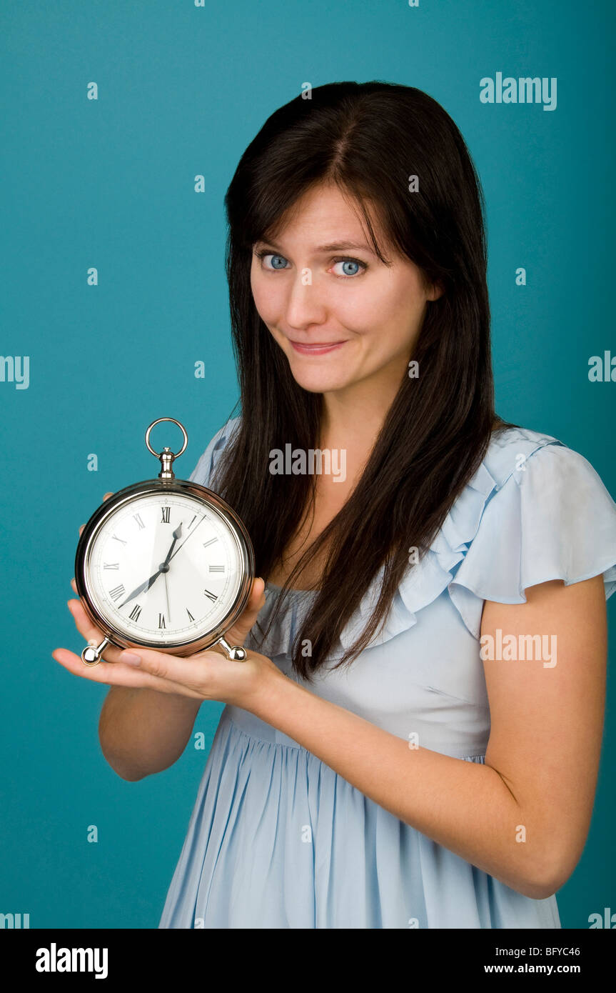 Woman holding clock Stock Photo - Alamy