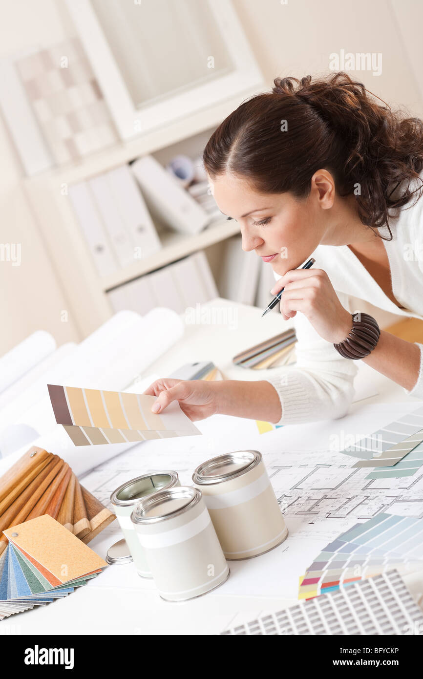 Young successful interior designer woman with cans of paint and color ...