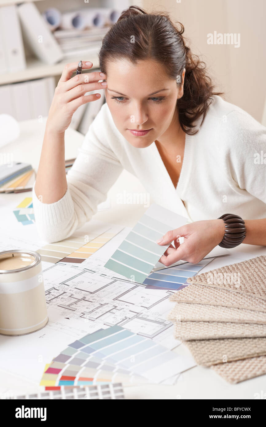 Young successful interior designer woman with cans of paint and color ...