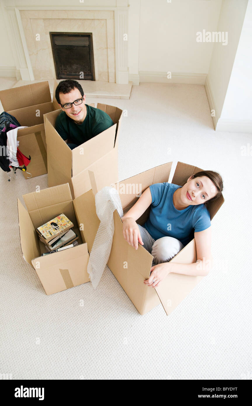 A couple sitting in cardboard boxes Stock Photo - Alamy