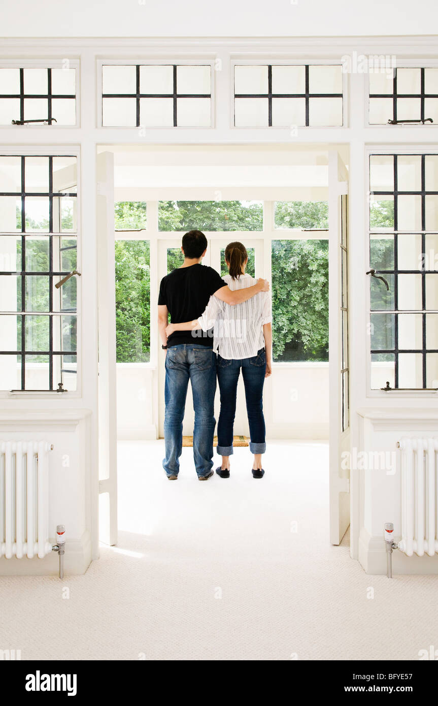 A young couple looking out of the window Stock Photo - Alamy
