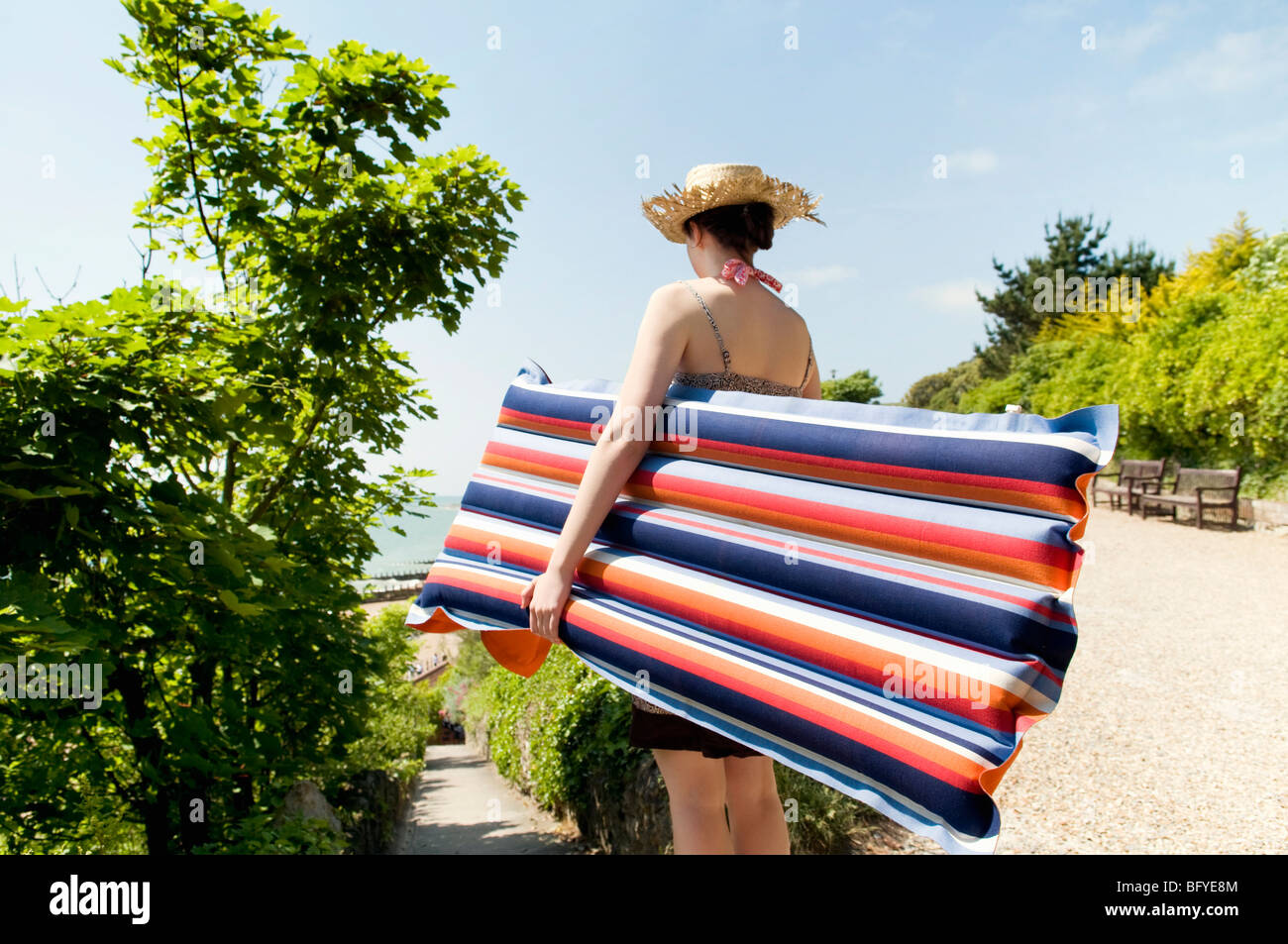 A girl with a Lilo going to the beach Stock Photo - Alamy