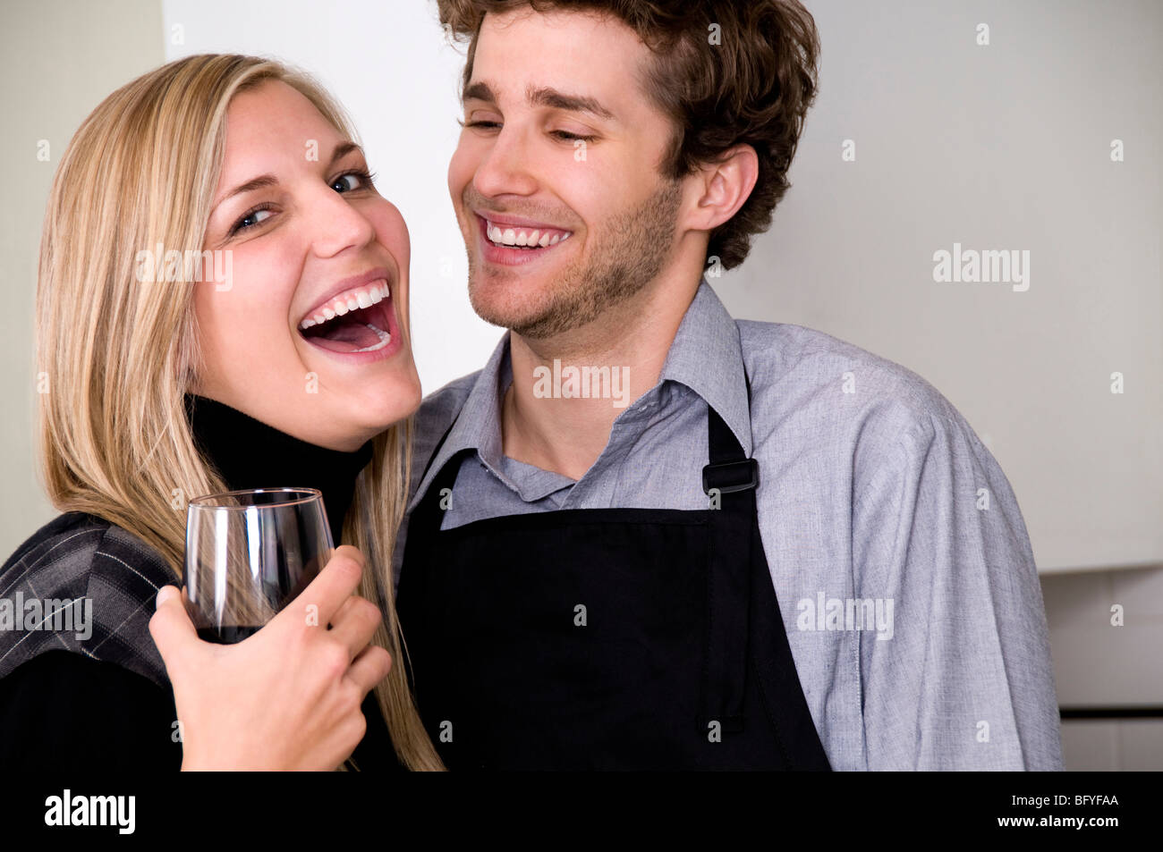 Couple laughing in kitchen Stock Photo - Alamy