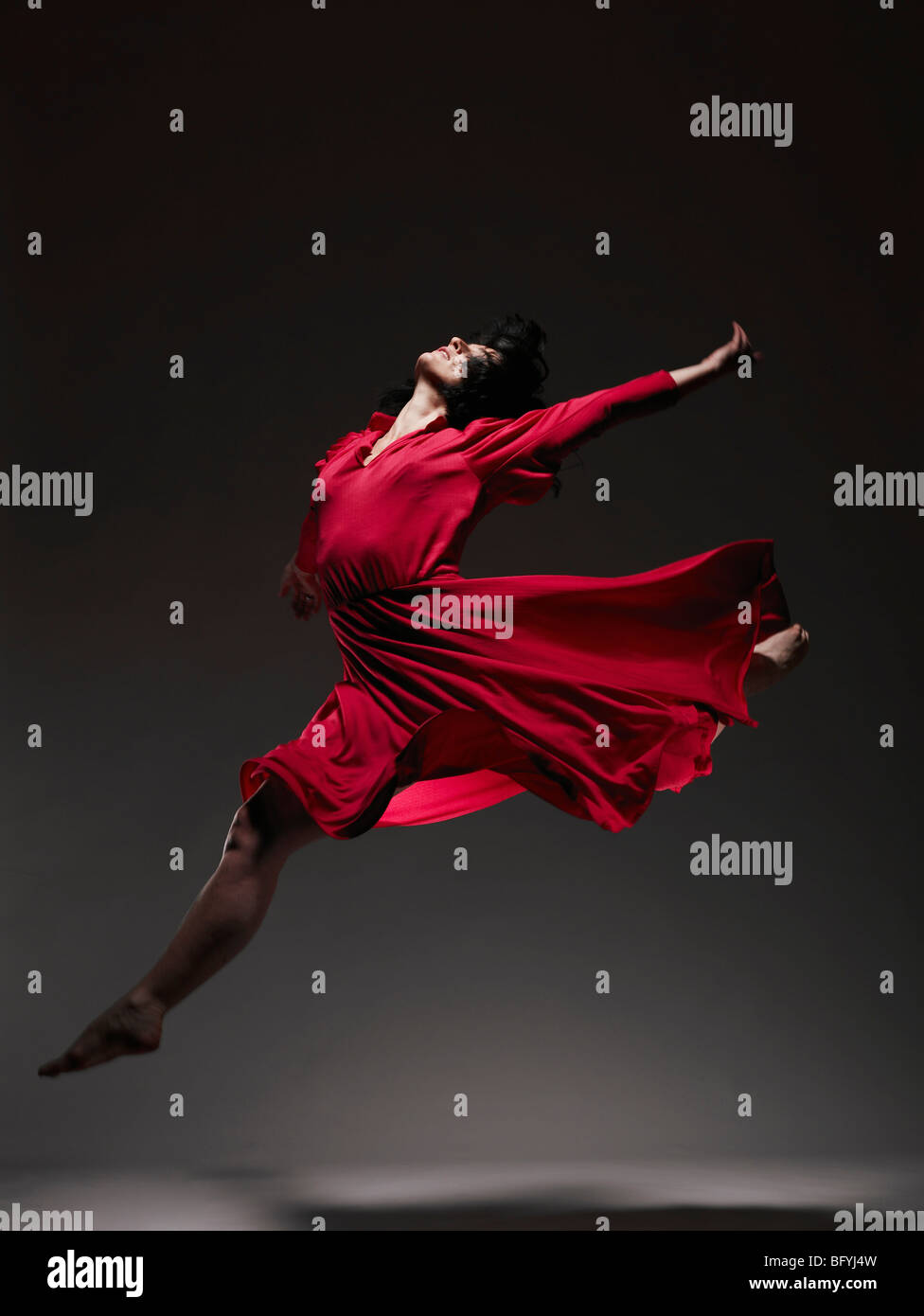 Woman in Red dress dancing under light Stock Photo - Alamy