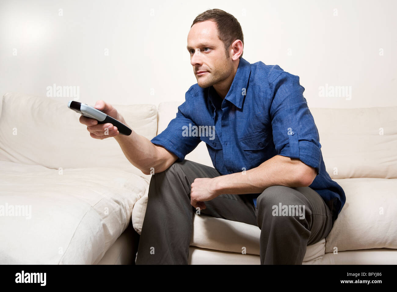 Man watching television in his living room Stock Photo - Alamy