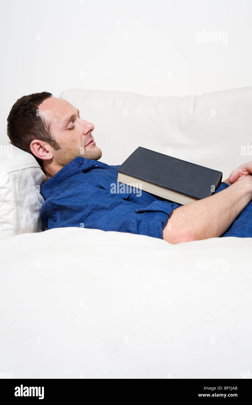 Man who has fallen asleep while reading a book at home Stock Photo - Alamy