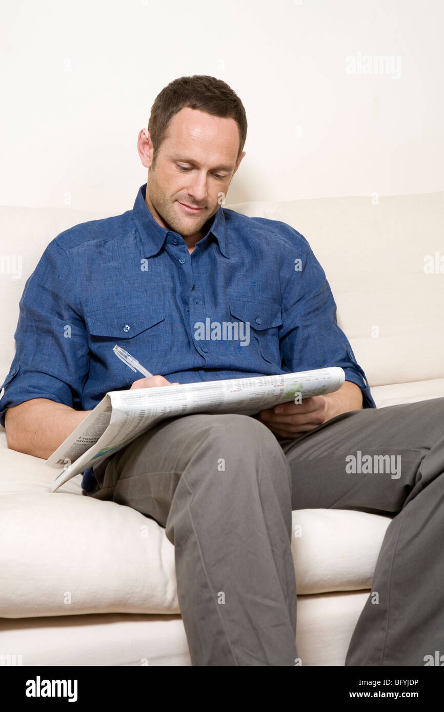 Man doing crossword puzzle at home Stock Photo - Alamy